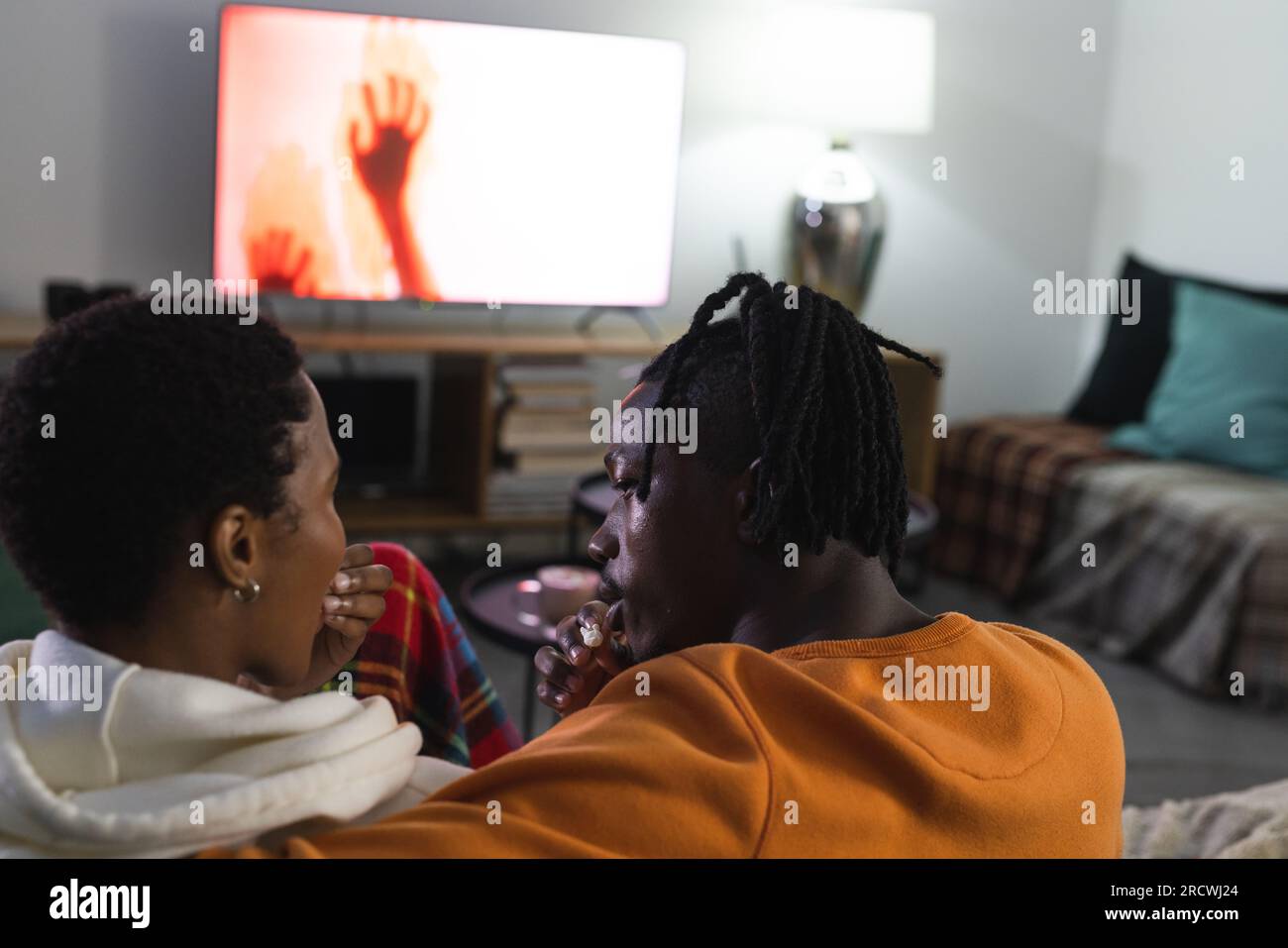 African american couple relaxing at home watching scary movie Stock ...