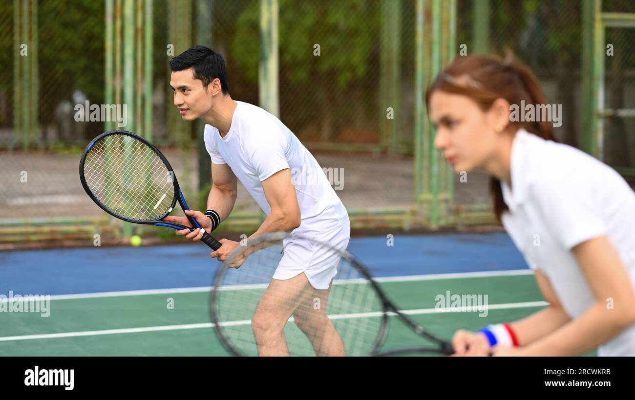 Two focused tennis player standing in ready position to receive a serve ...