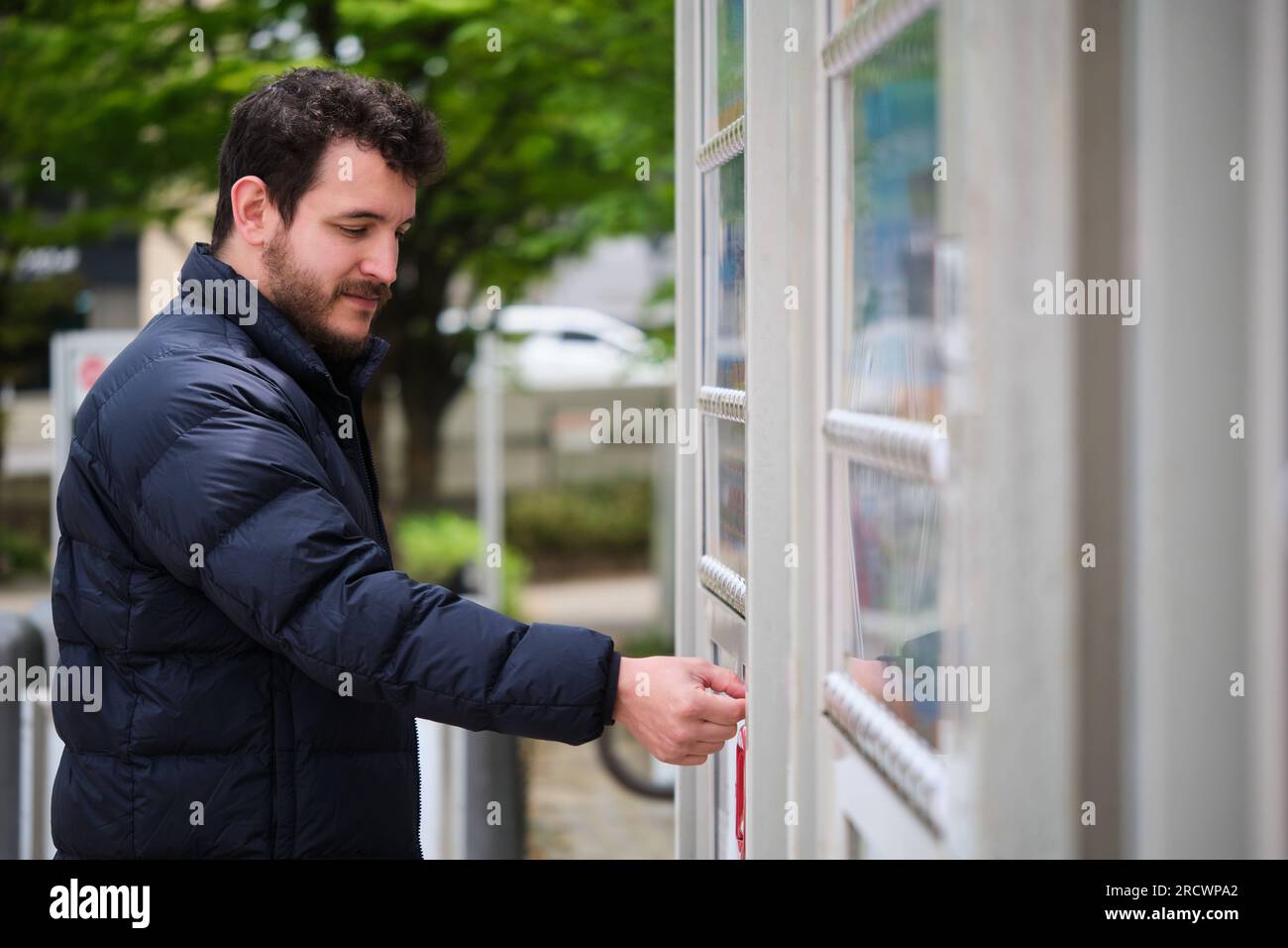 European tourist buying a drink in a japanese vending machine ...