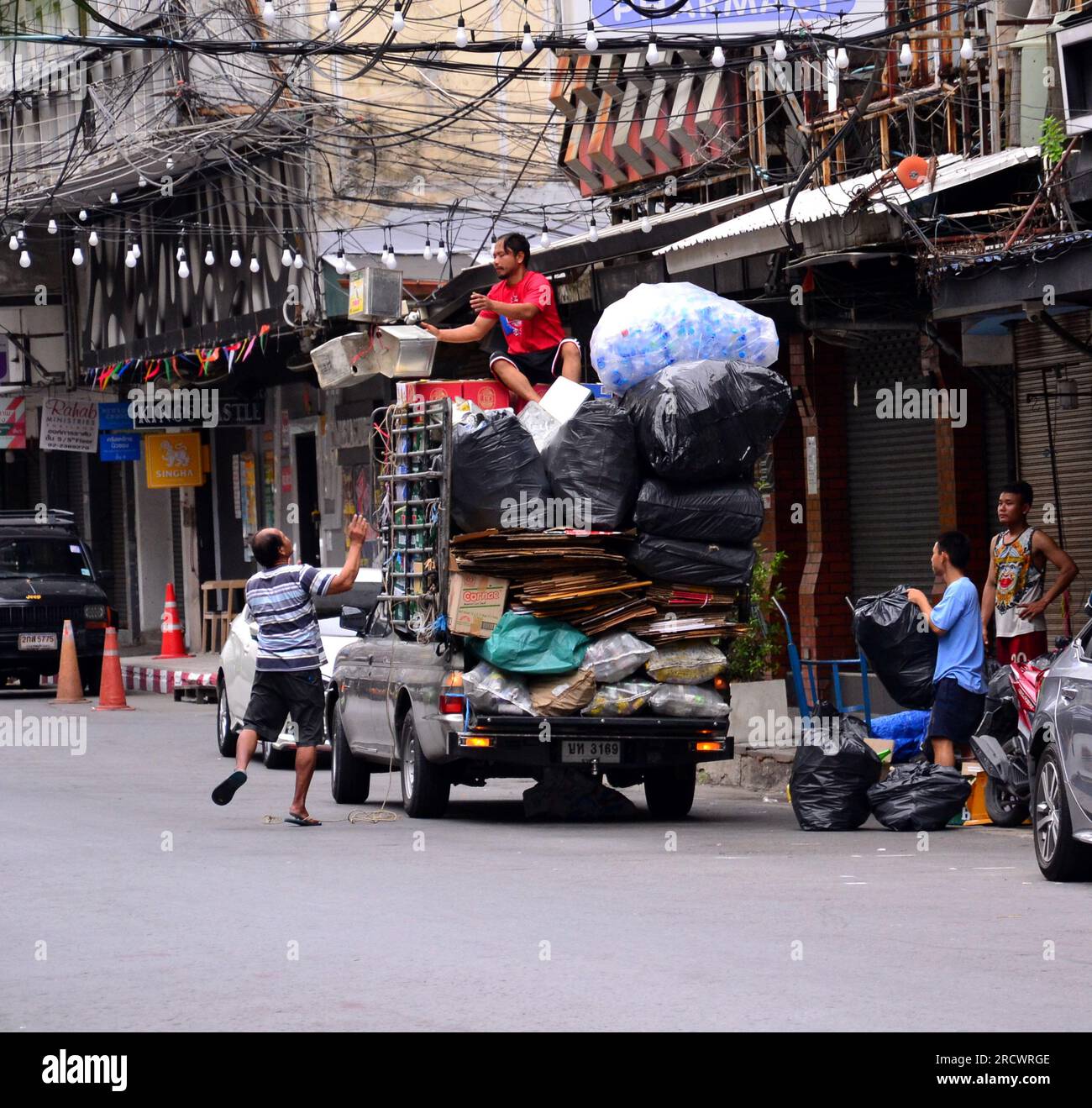 Men collect recycling materials on a truck in Bangkok, Thailand, Asia ...