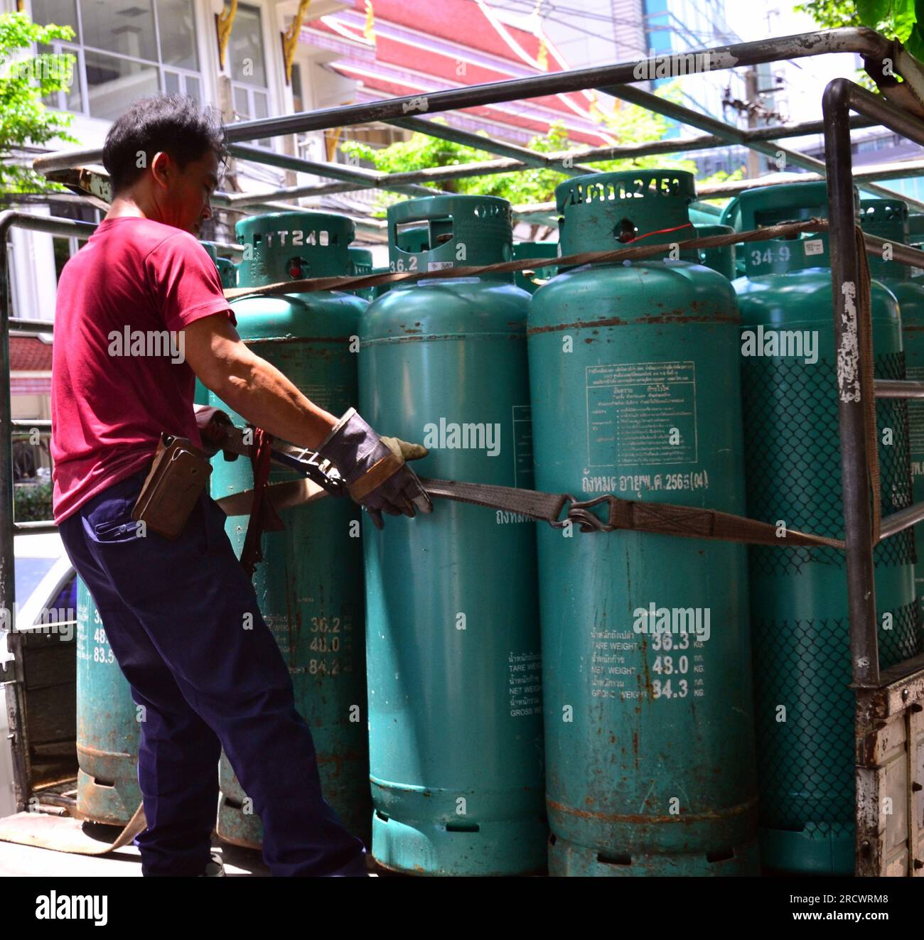 Man delivering gas fuel bottles, commonly used for cooking, in Bangkok ...