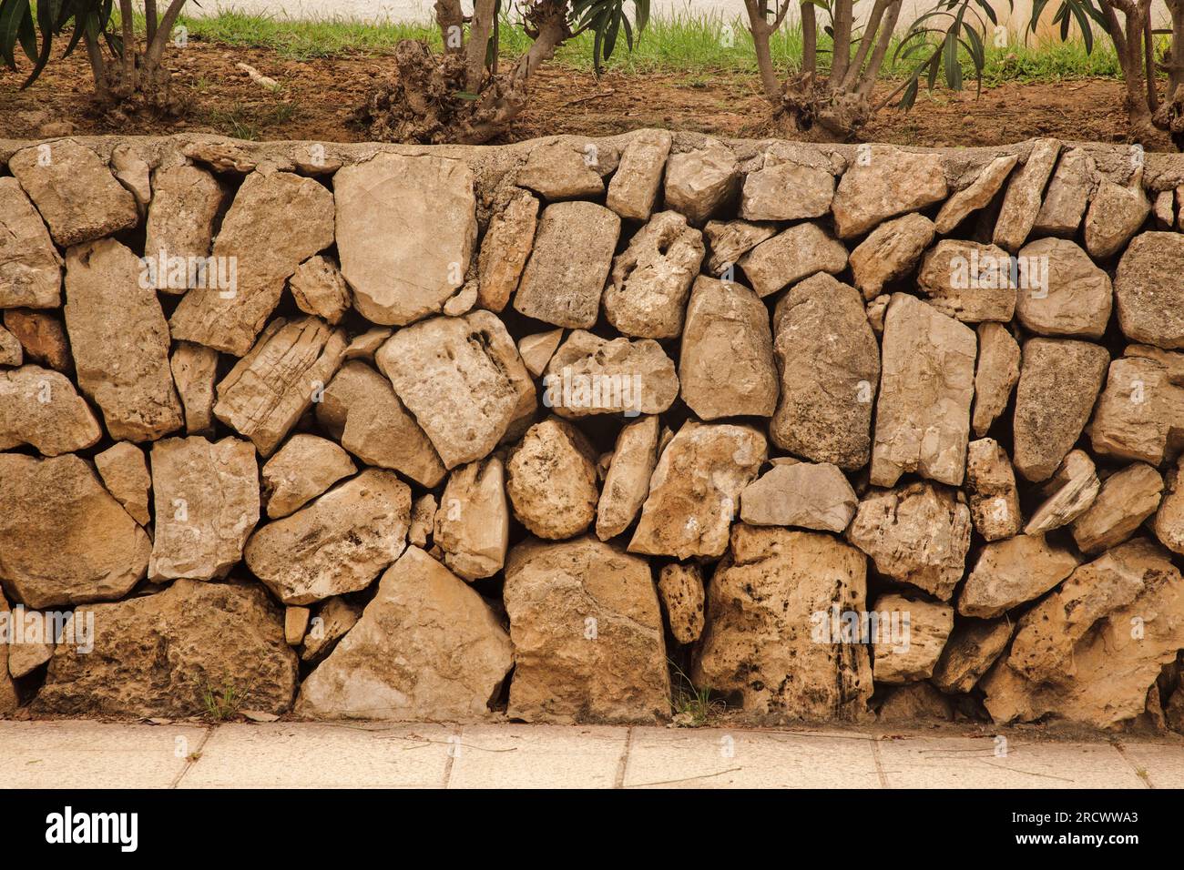 stone support brick wall in spain along a sidewalk Stock Photo - Alamy