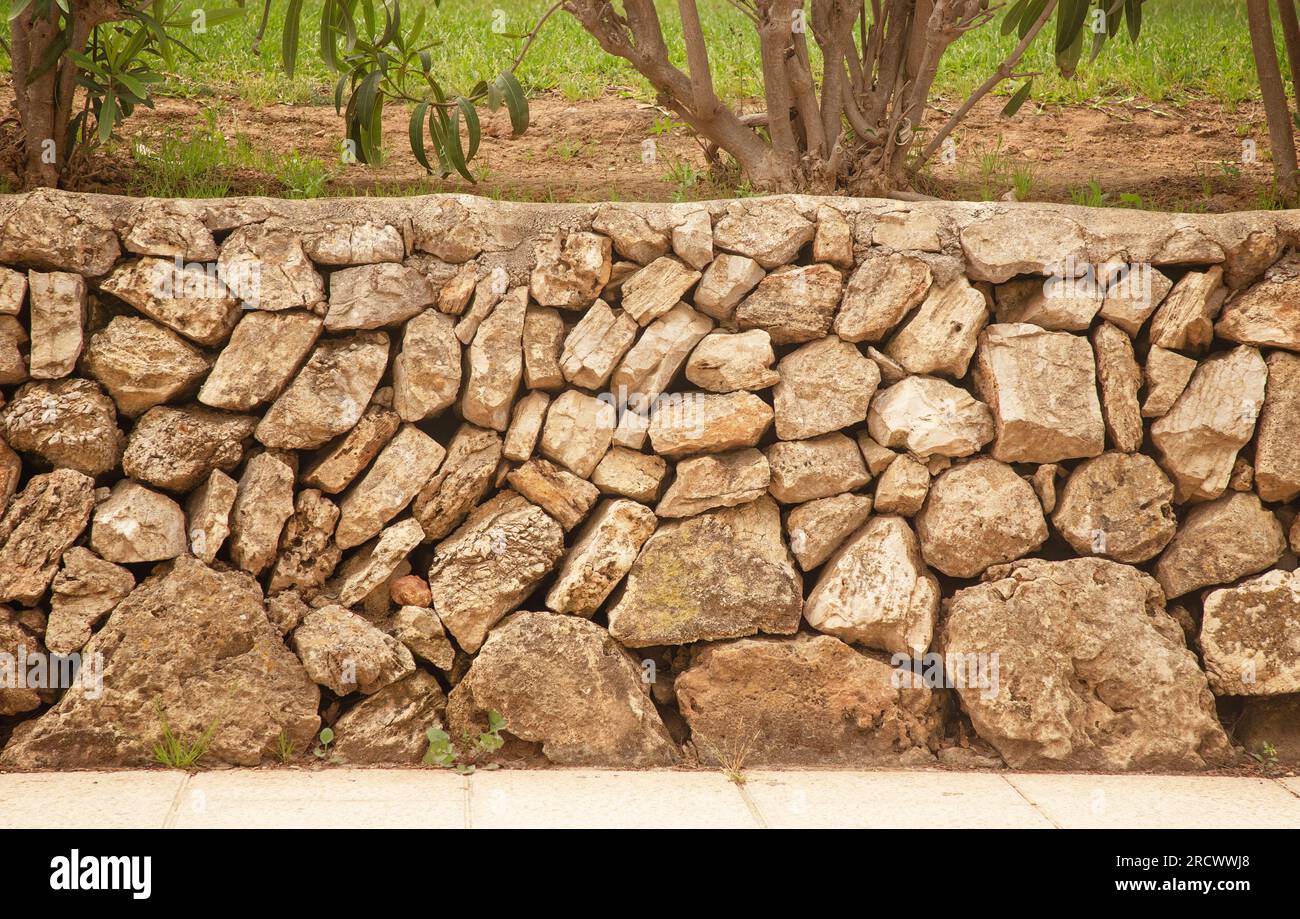 stone support brick wall in spain along a sidewalk Stock Photo - Alamy