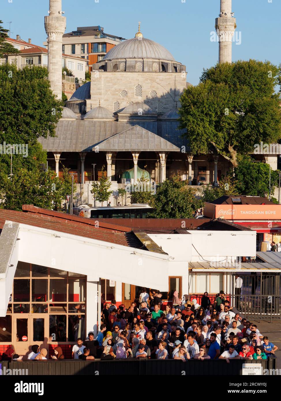 A crowd of people queue for a ferry on a summers evening in Uskudar ...