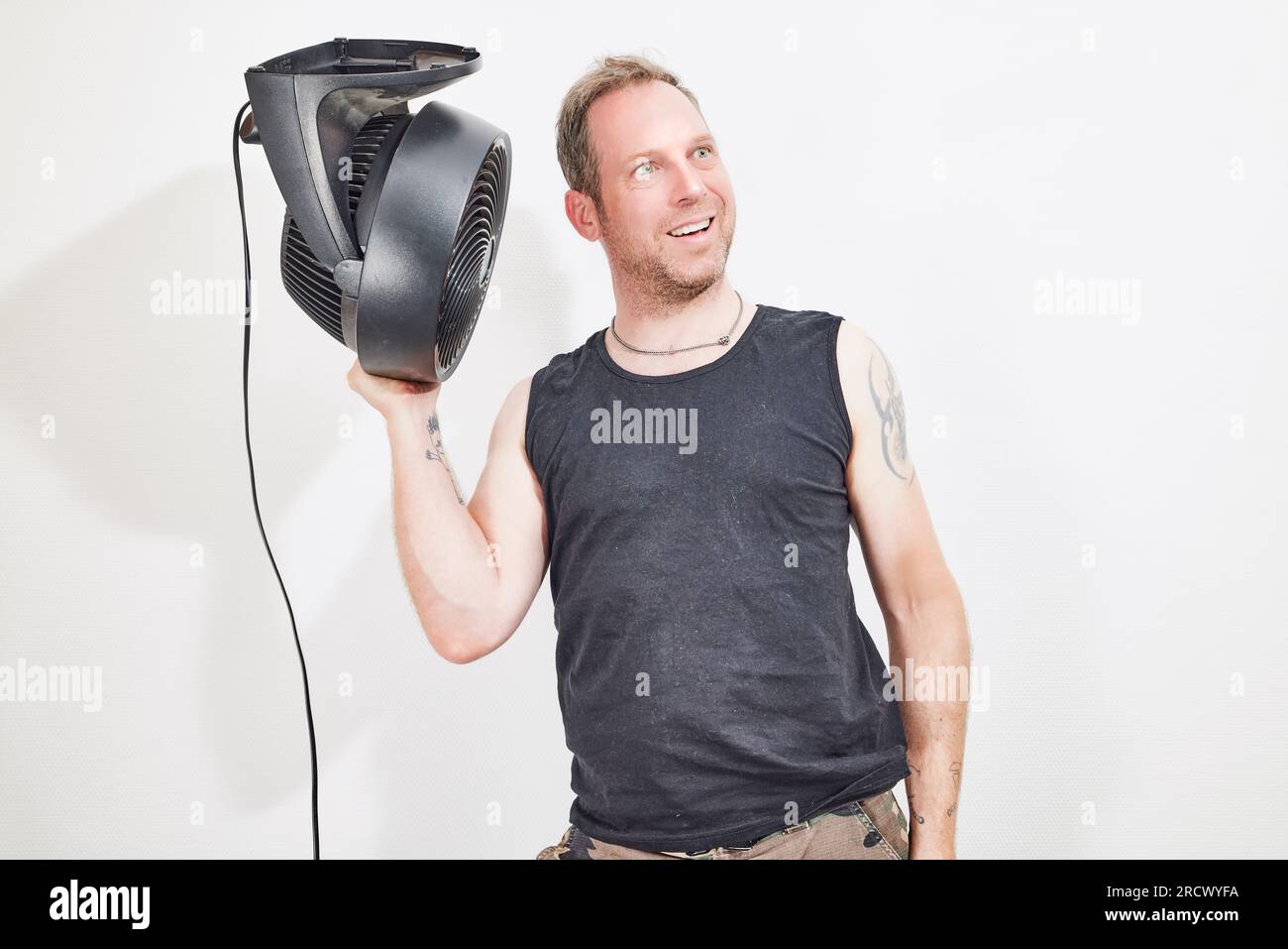 Man holding fan to cool the face Stock Photo - Alamy