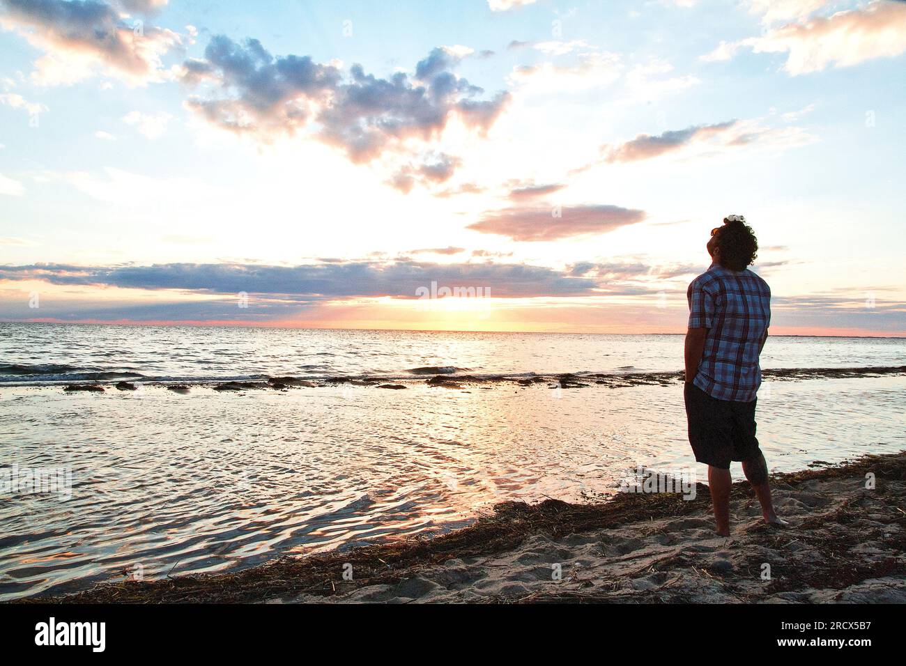 A man with head back, soaking in the Cape Cod sunset on a beach Stock ...