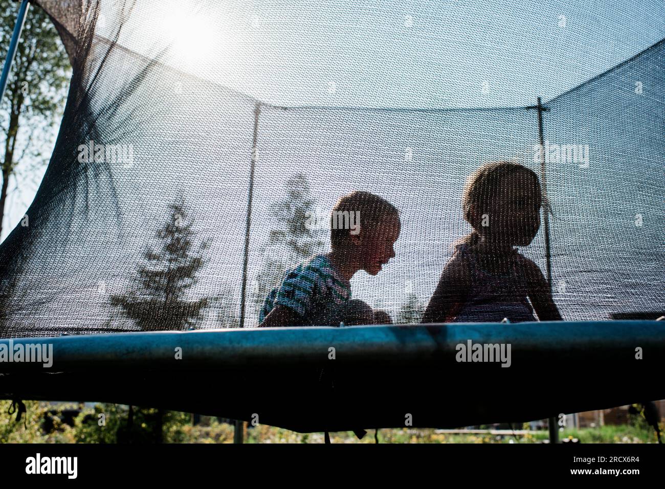 two kids playing on a trampoline having fun Stock Photo - Alamy