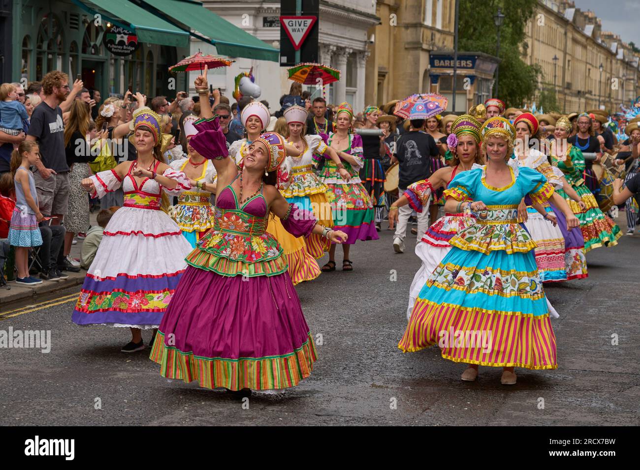 Dancers and musicians dressed in ornate costumes parade through the ...