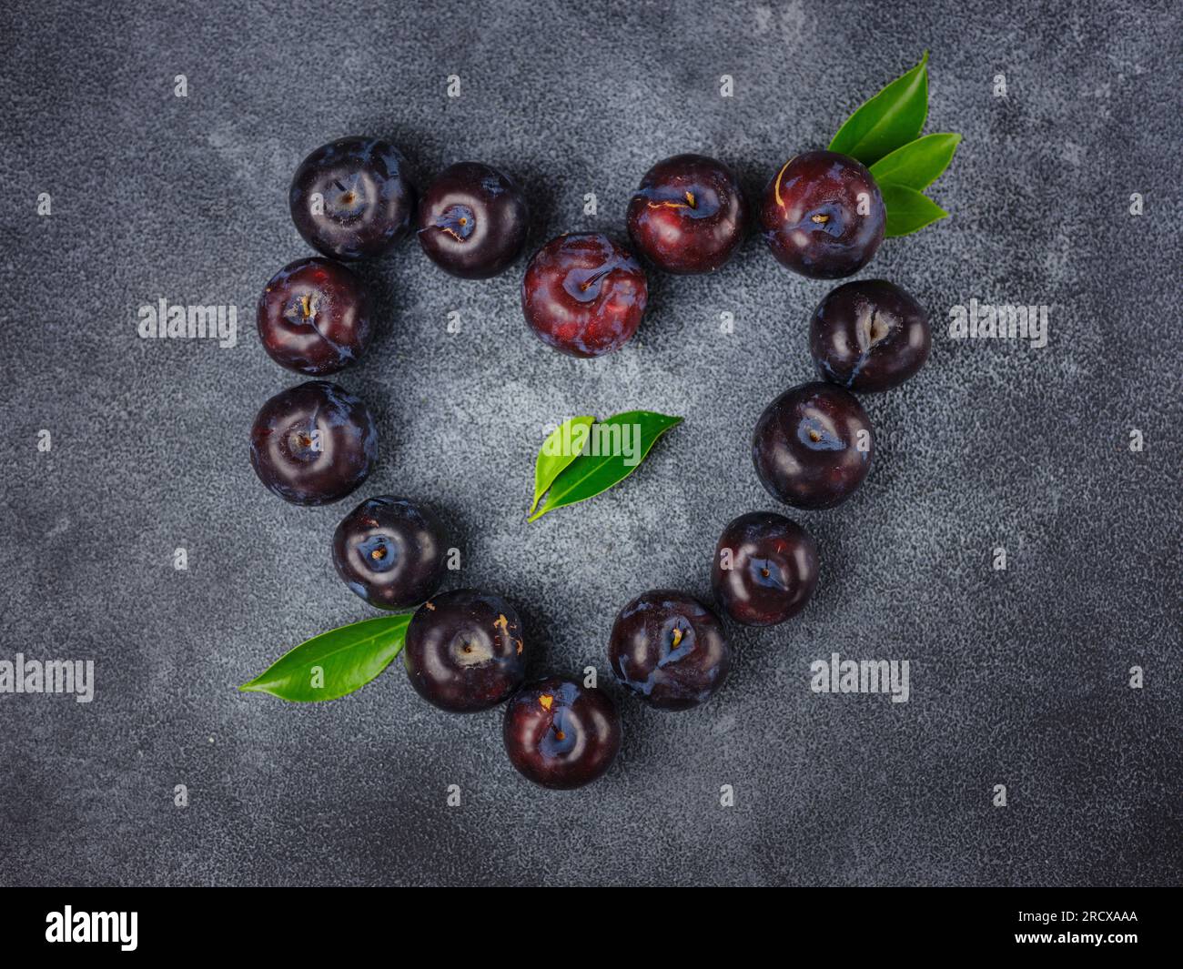 Sweet plums on dark background. Fresh blue plums with leaves. Food ...