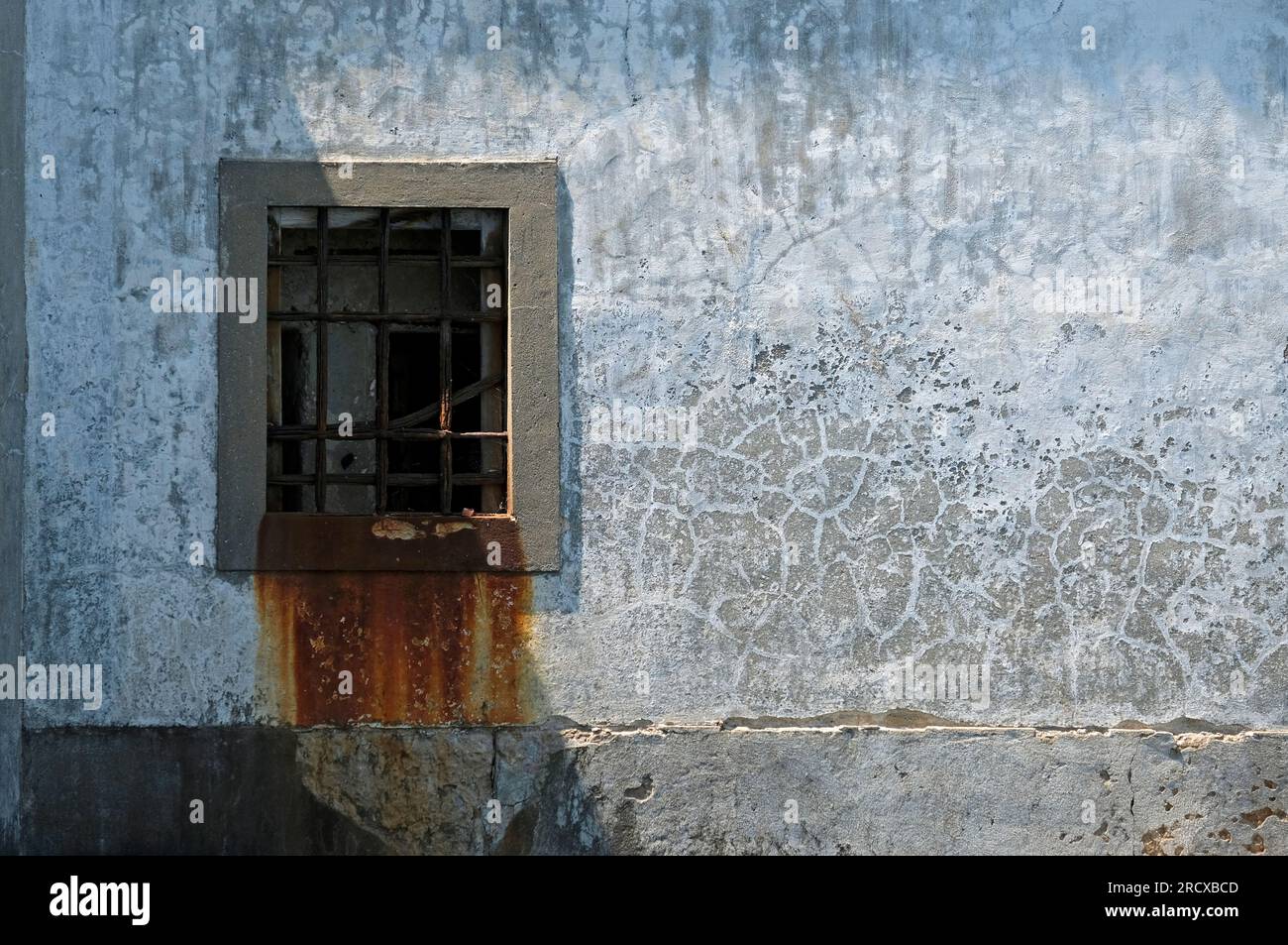 Rust coloring a wall underneath a gated window Stock Photo - Alamy