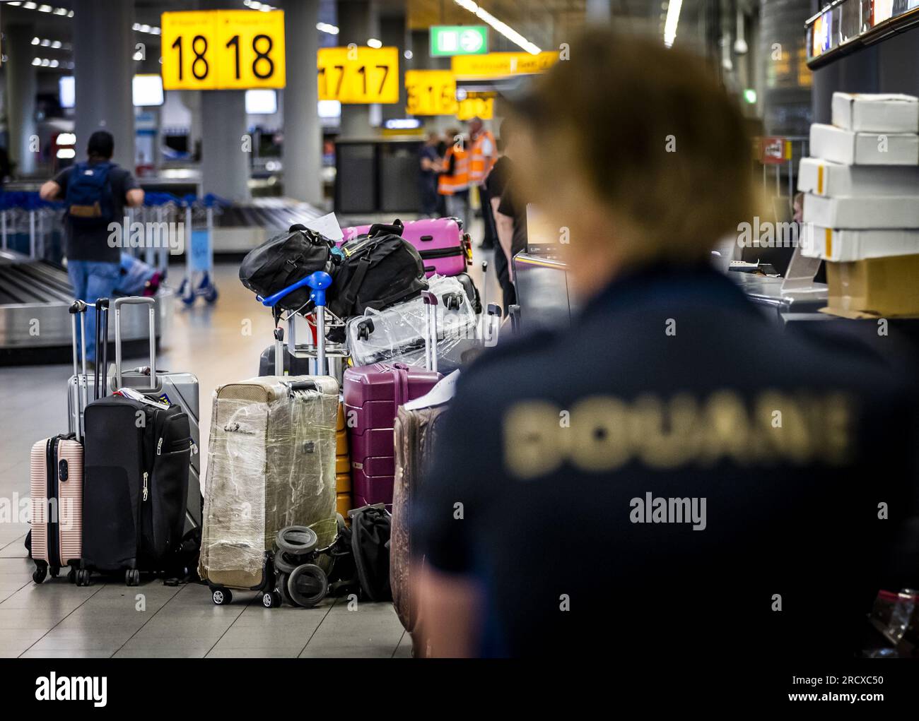 SCHIPHOL - A customs officer in the arrivals hall at Schiphol Airport ...