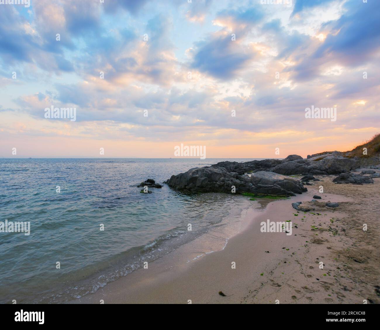 cozy sea shore with sand and rocks at dawn. beautiful view in to the ...