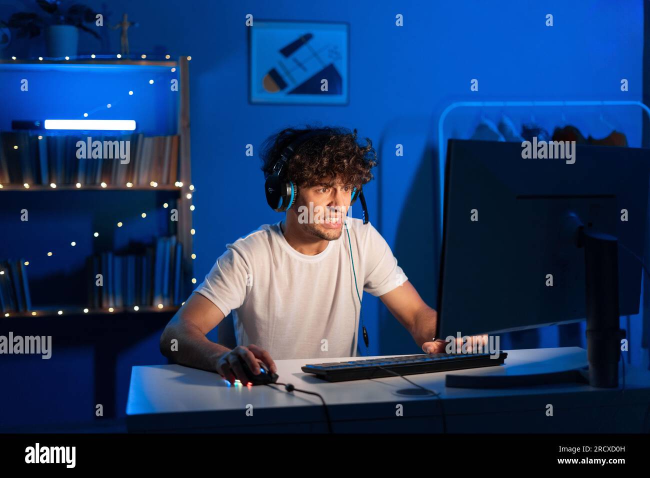 Arabic angry guy gamer playing video games on computer with neon light ...