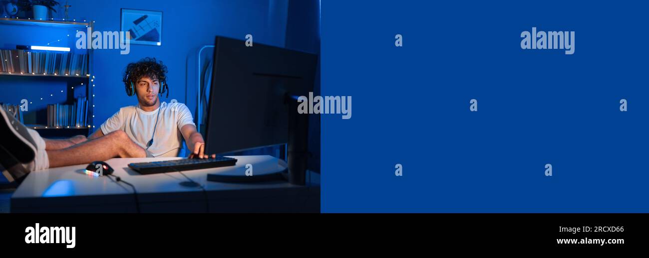 An Arab gamer playing video games on the computer put his feet on the ...