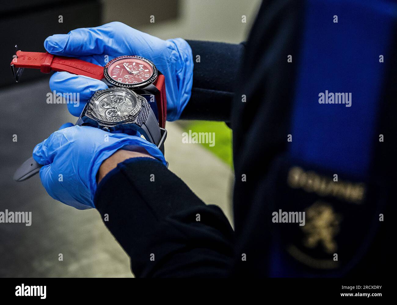SCHIPHOL - A customs officer inspects a suitcase at Schiphol Airport ...