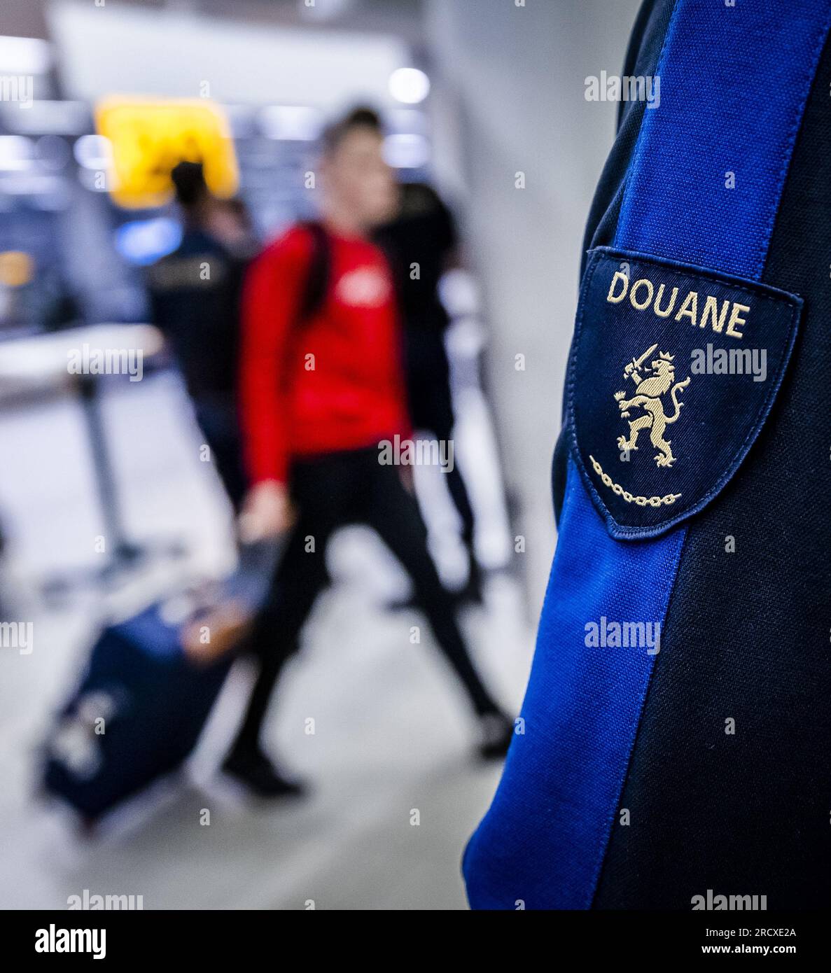 SCHIPHOL - A customs officer inspects a suitcase at Schiphol Airport ...