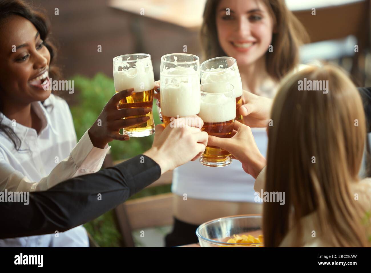 Positive, young people, colleagues, employees meeting at pub, cafe ...