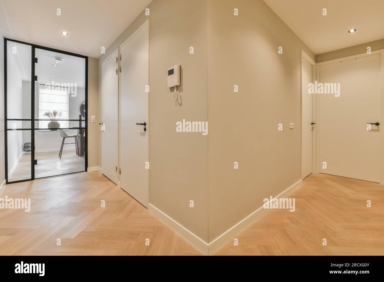 an empty room with wooden floors and white walls, there is a door ...