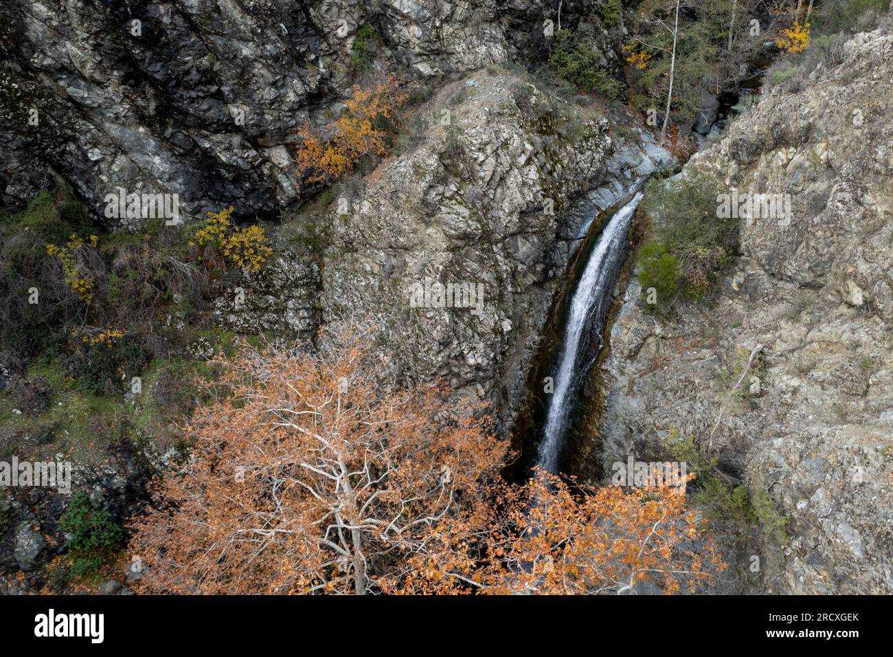 Drone aerial of waterfall flowing from a rocky cliff in autumn. Nature ...