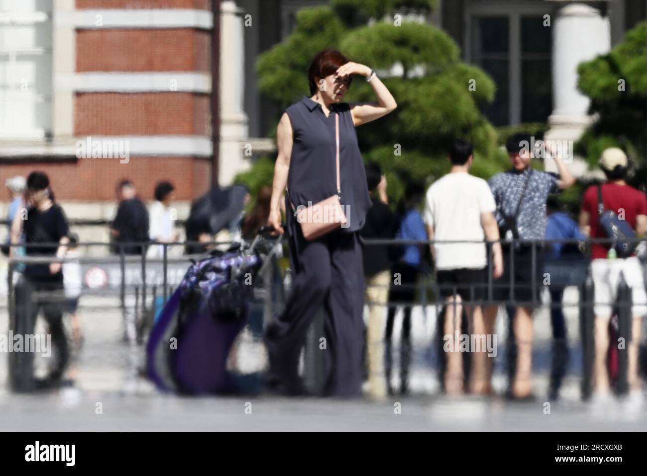 People walk on a sweltering hot day near JR Tokyo Station in the ...