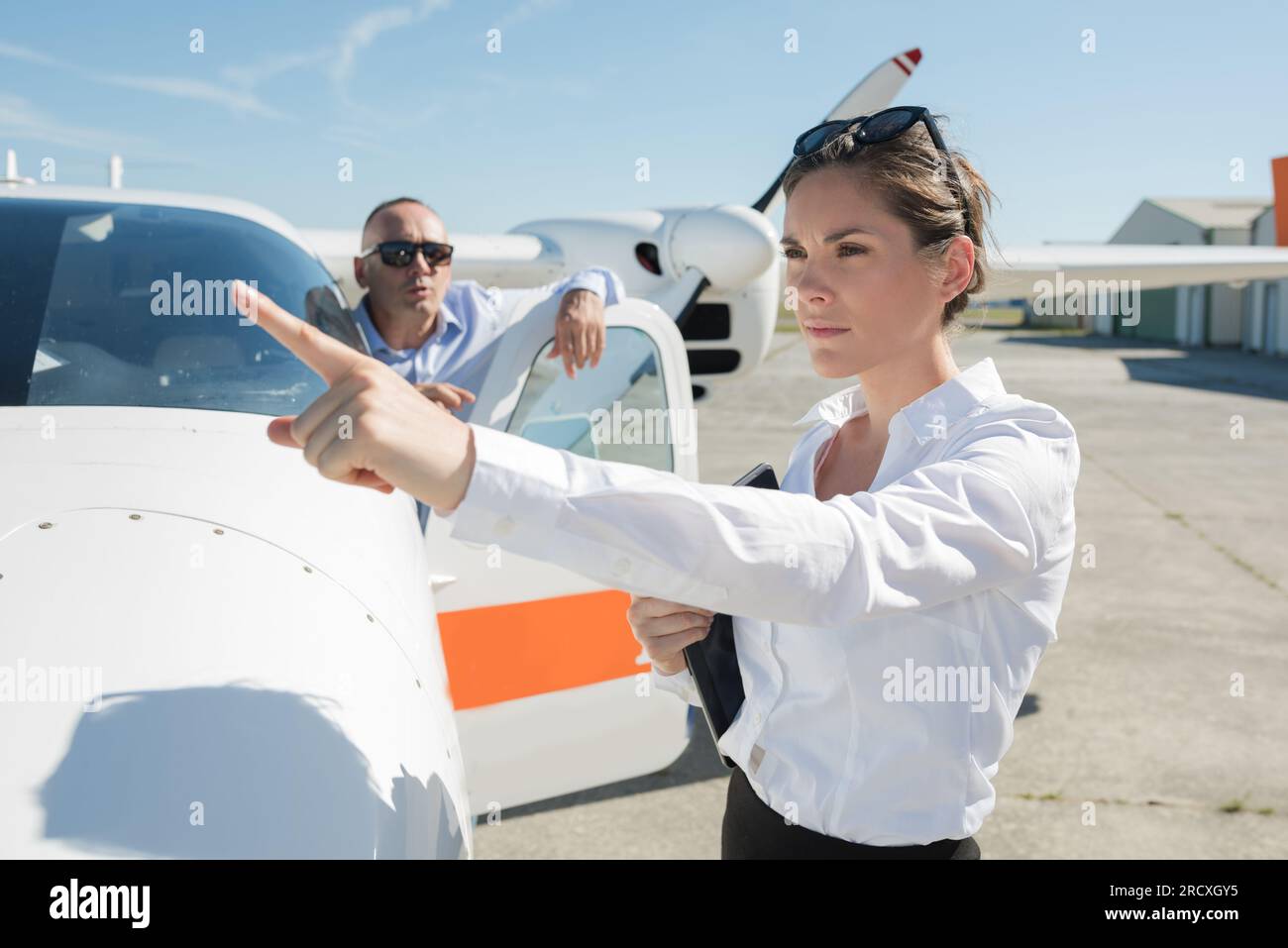 woman pointing at distance beside private aircraft Stock Photo - Alamy