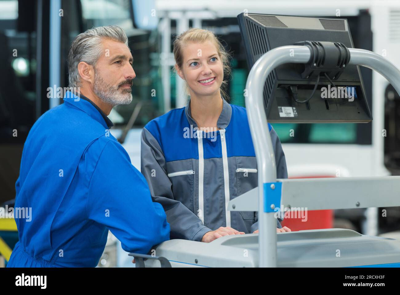 picture of male and female factory workers observing something Stock ...