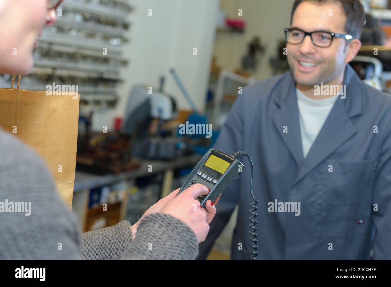 customer entering pin code to make card payment to cobbler Stock Photo ...