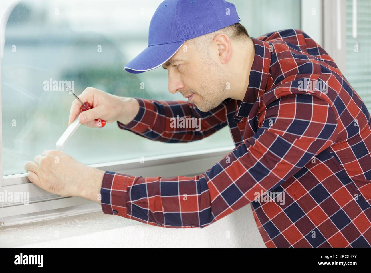 handyman using tools to repair a window indoors Stock Photo - Alamy