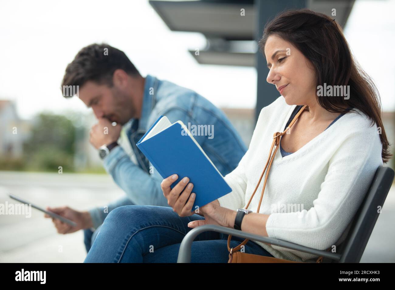 woman and man passengers waiting for bus Stock Photo - Alamy