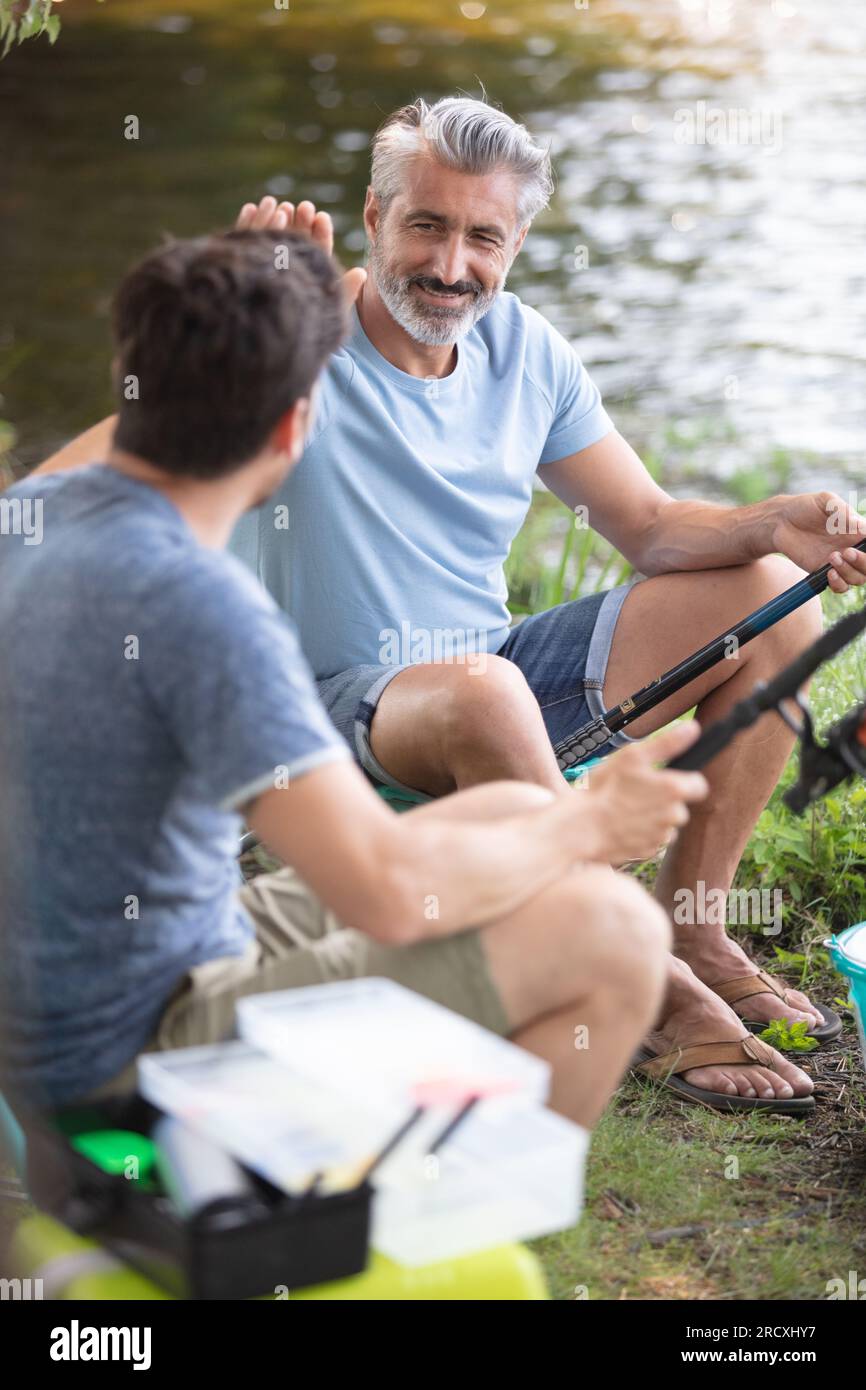 two men are fishing outdoors Stock Photo - Alamy