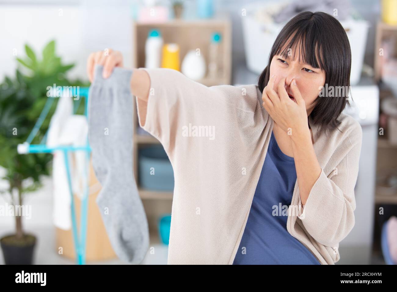 woman holding dirty stinky socks Stock Photo - Alamy