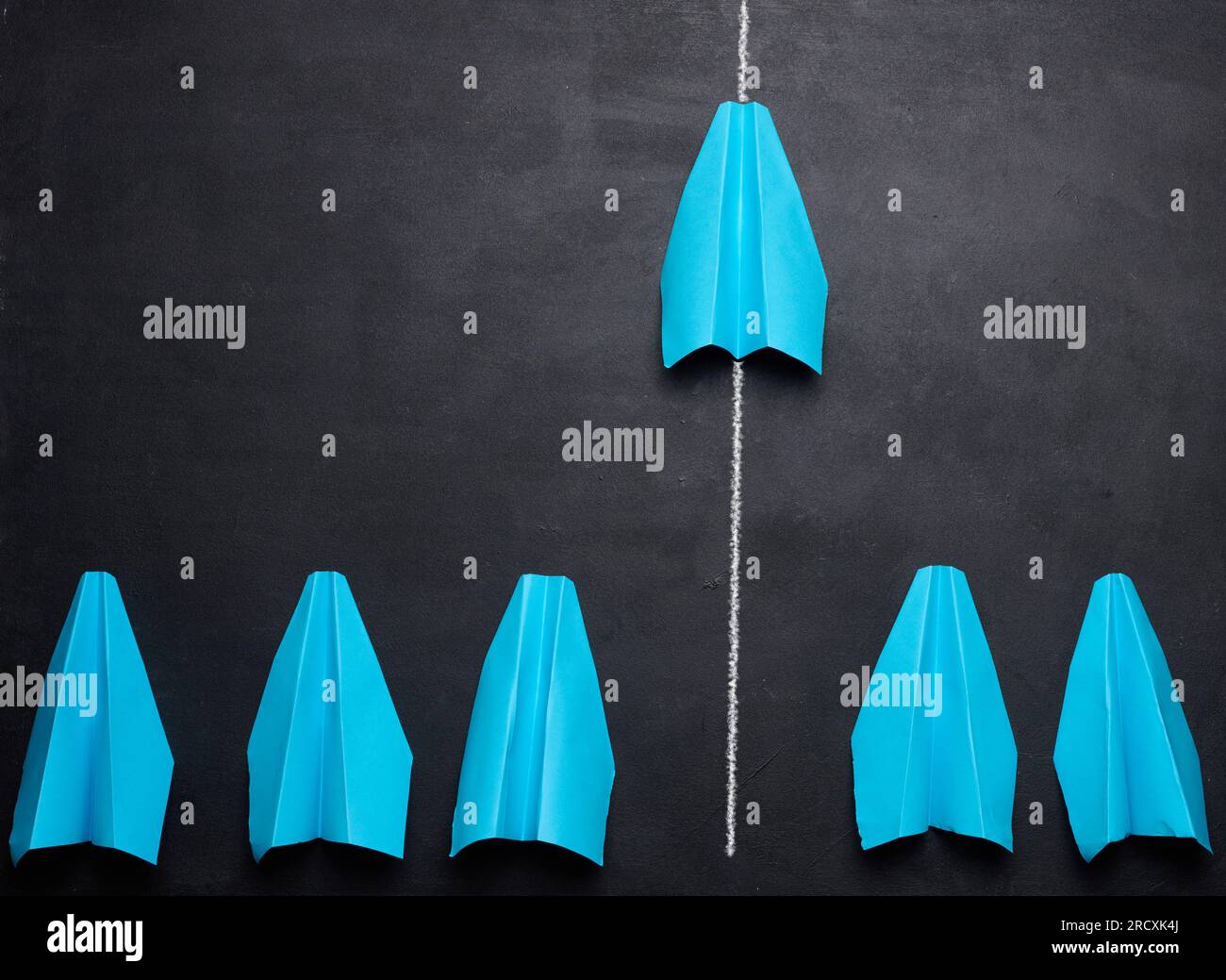 A group of paper blue airplanes with one leading ahead, concept of a ...