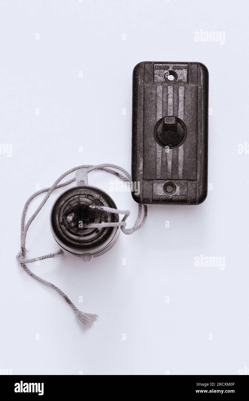 A small brown, flat Bakelite wall switch with 3 stripes and an ...