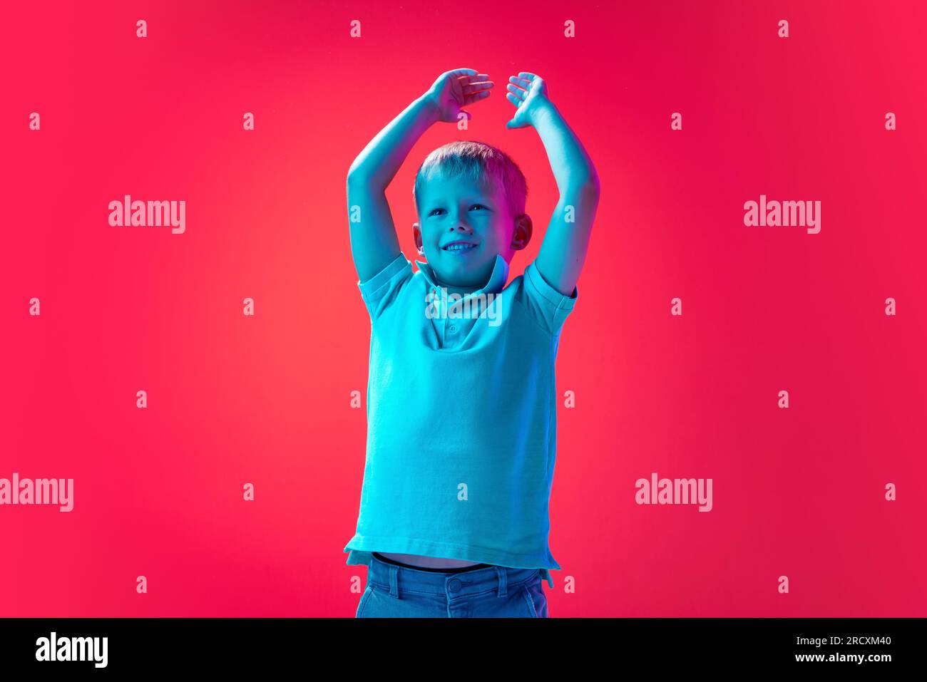 Portrait of smiling little boy, child raising hands up, feeling excited ...