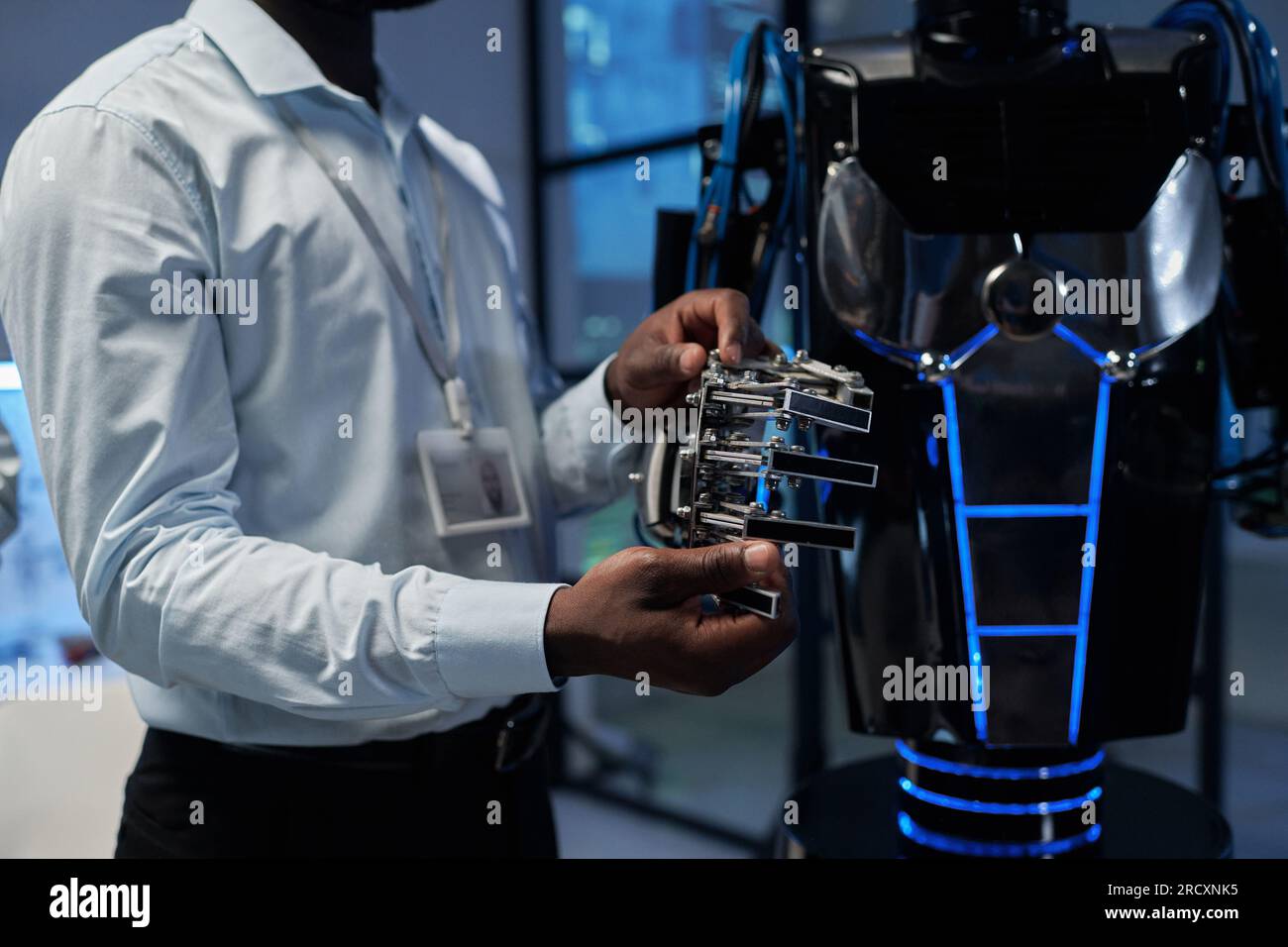 Close-up of African American engineer examining the structure of robot ...