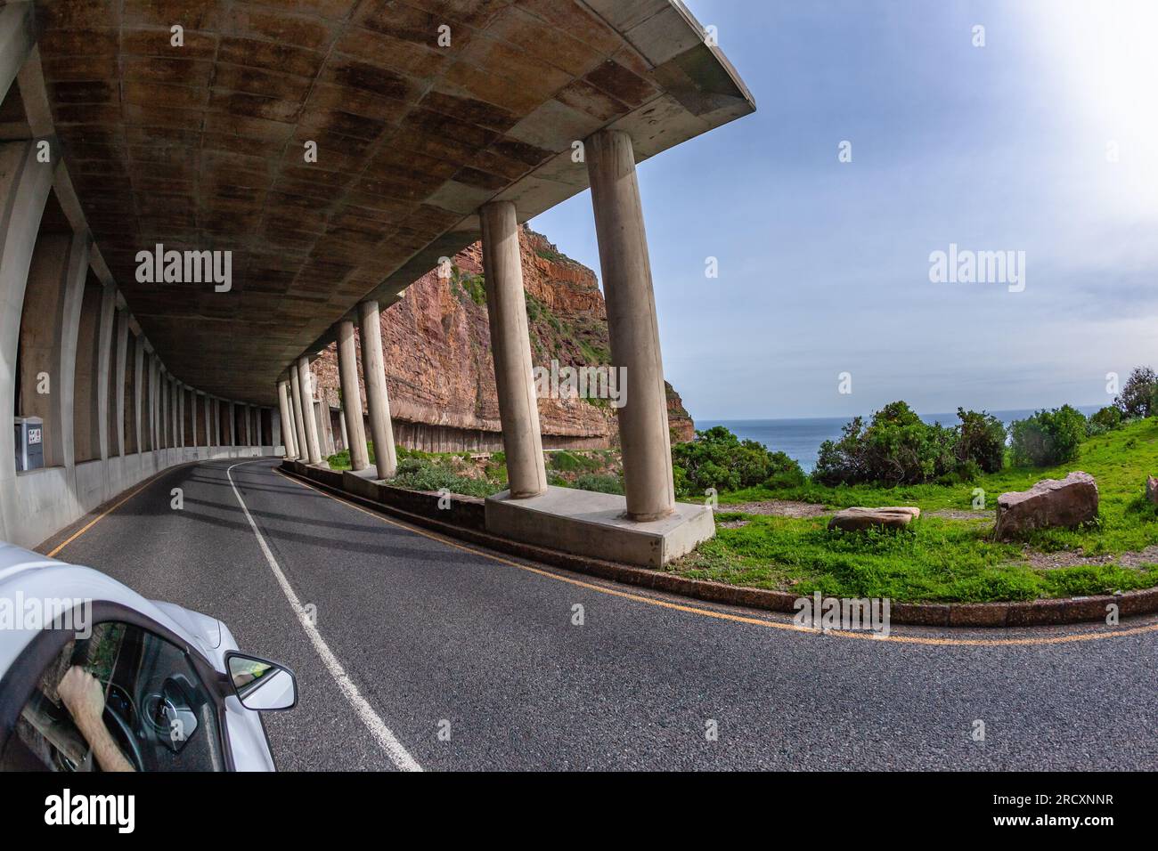 Driving on narrow road overhead tunnel pass overlooking scenic Atlantic ...
