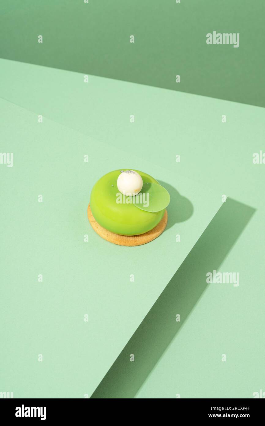 A freshly baked pastry with green and white icing, sitting atop a green ...