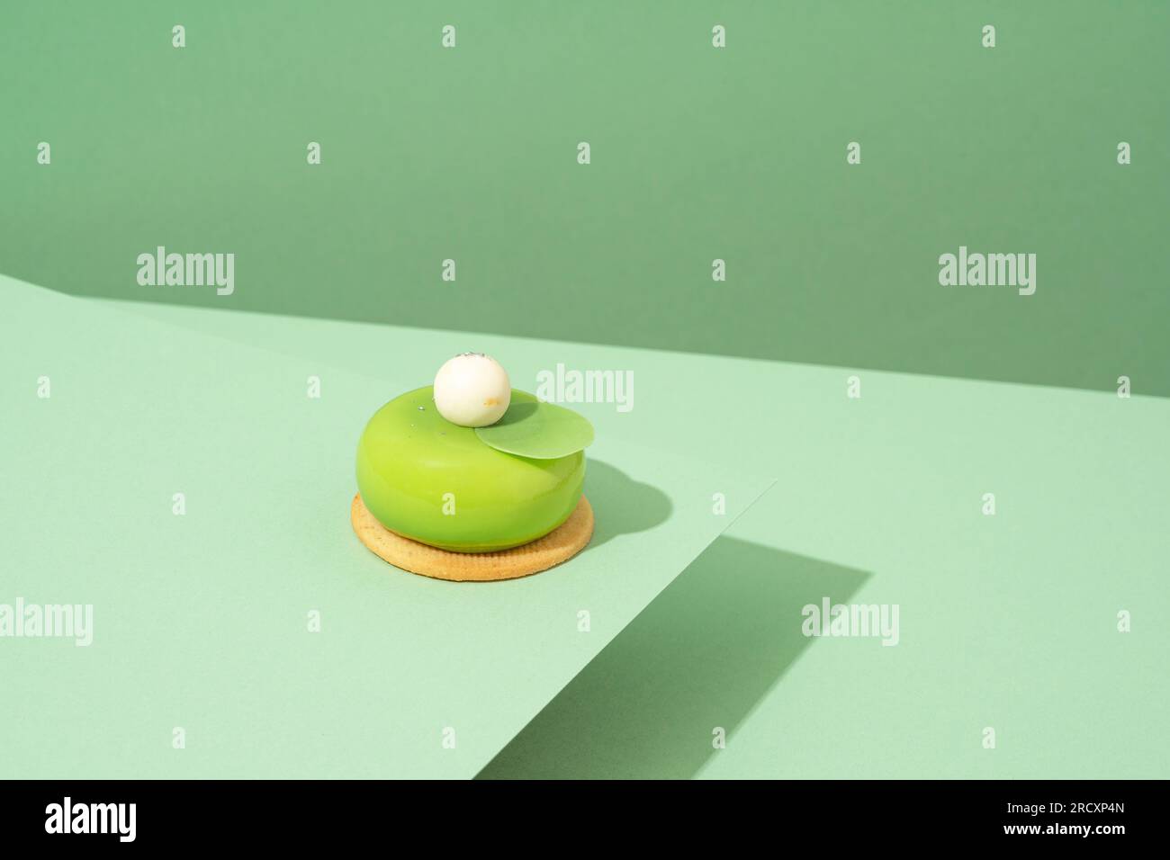 A freshly baked pastry with green and white icing, sitting atop a green ...