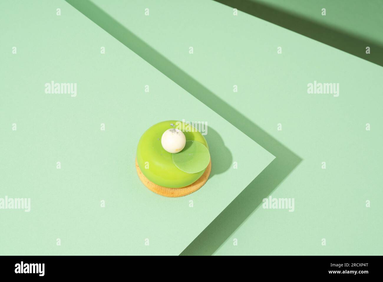 A freshly baked pastry with green and white icing, sitting atop a green ...