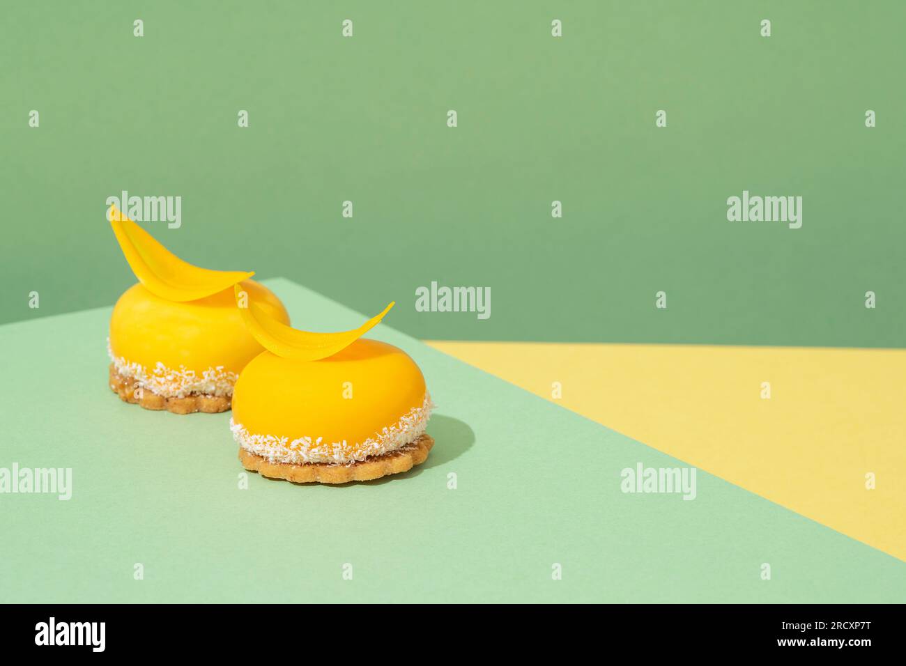 Two miniature, yellow-colored sweet treats set atop a blue and yellow ...