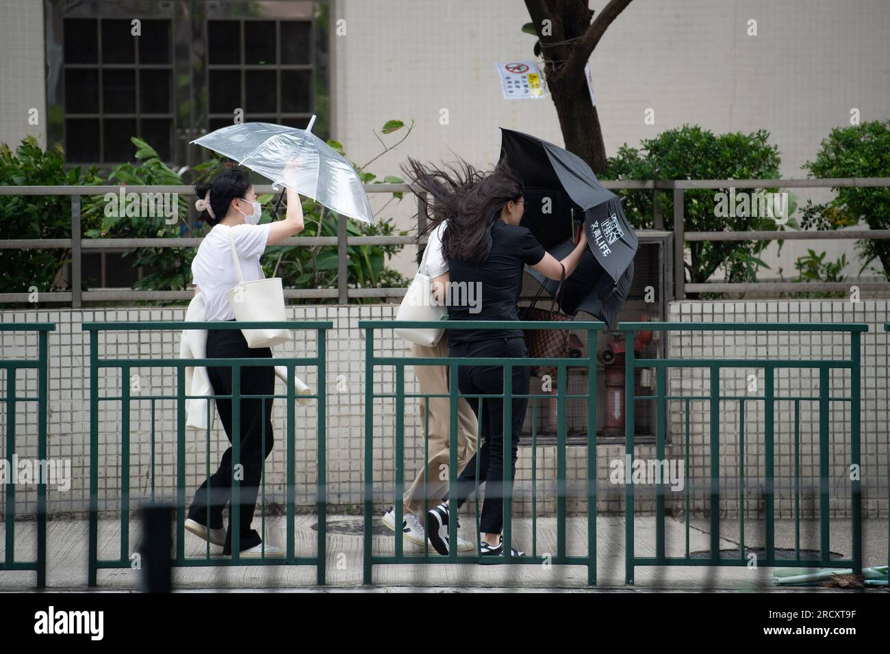 Macao, China. 17th July, 2023. Local residents walk in rain as Typhoon ...