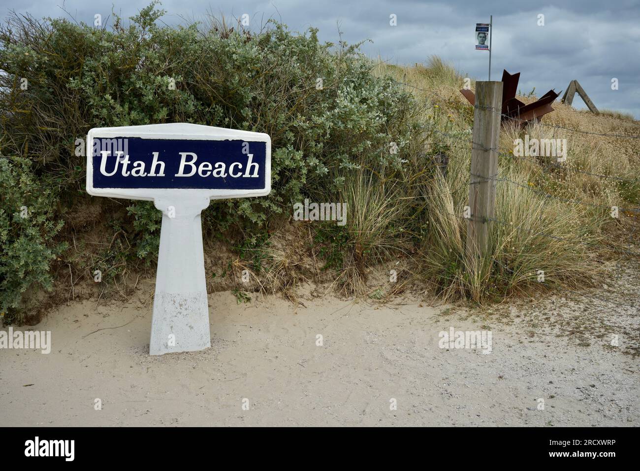 Concrete Utah Beach Sign by a wooden fence with metal beach defence ...