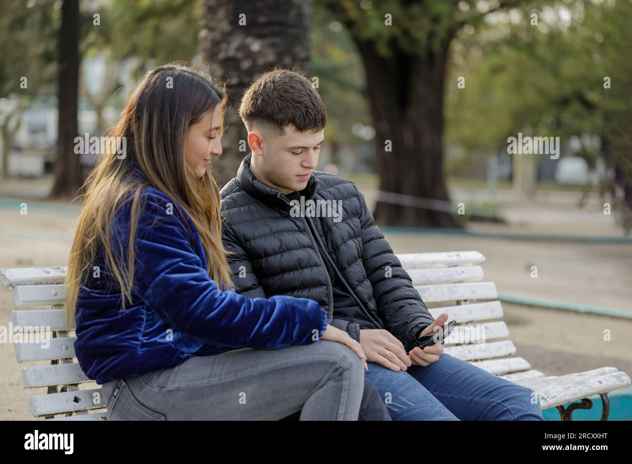 Young woman phone sitting on bench at park hi-res stock photography and ...