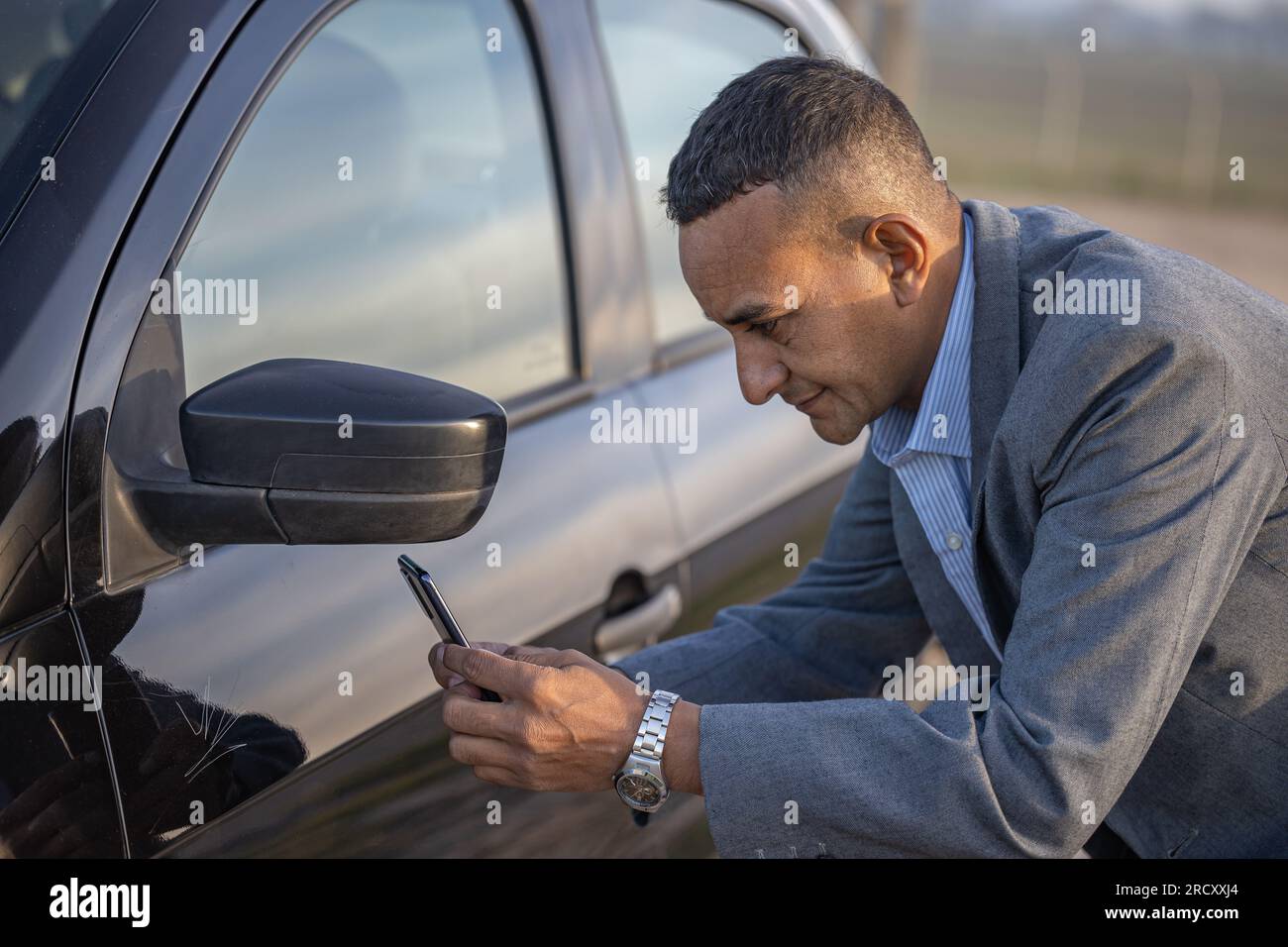 Insurance agent taking a picture of a car with a scratch Stock Photo ...