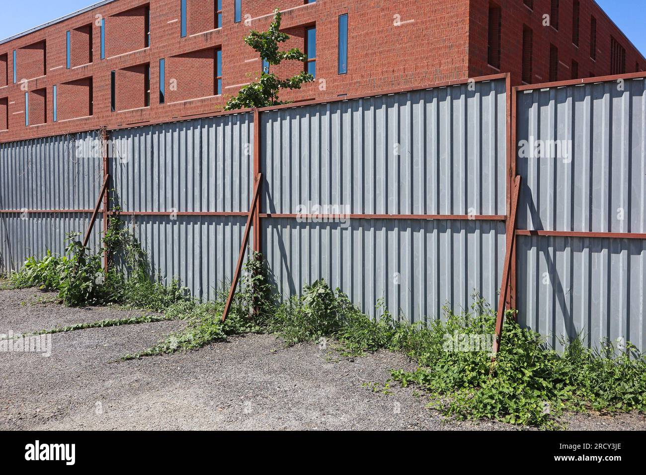 Metal fence in front of a brick building Stock Photo - Alamy