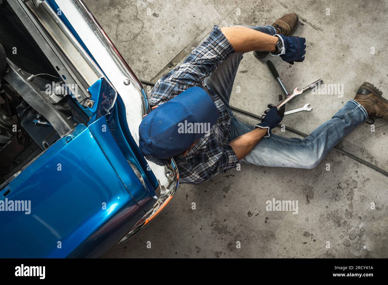 Tired Classic Cars Mechanic Resting on a Garage Floor Next to His ...