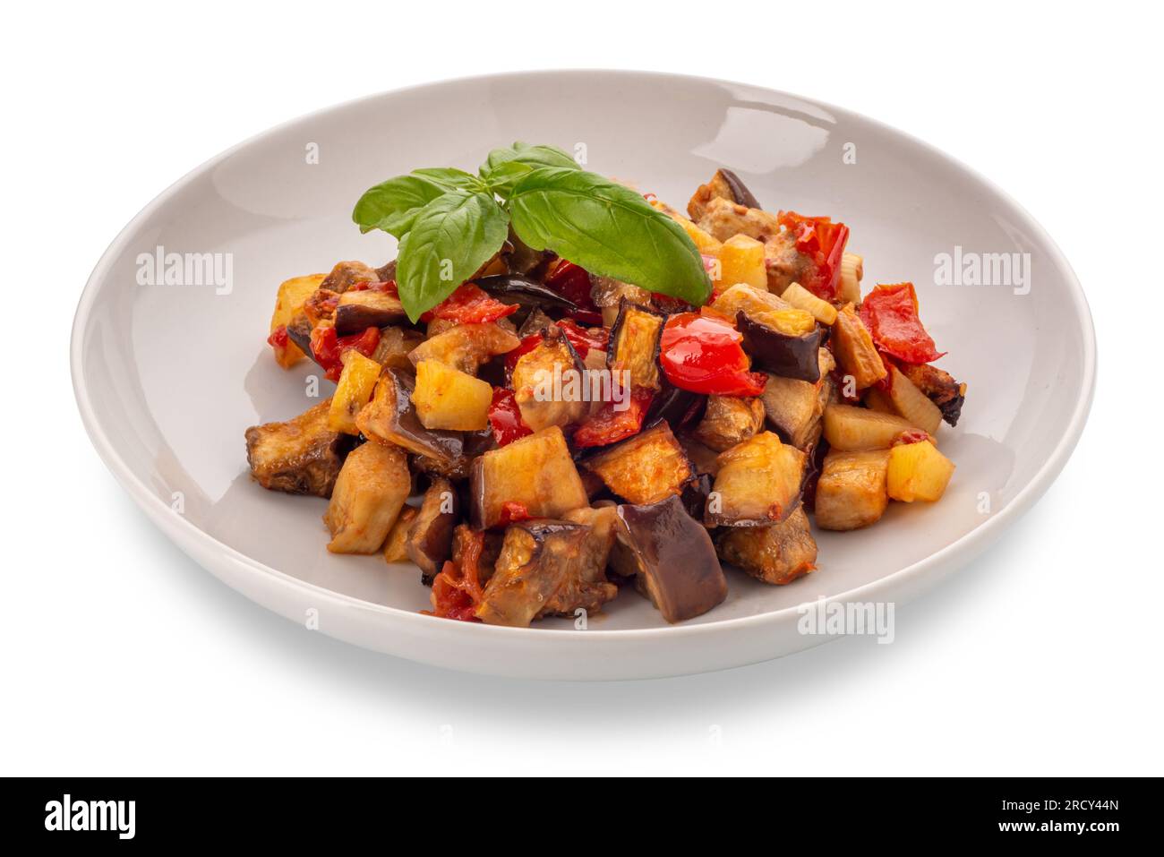 Traditional Italian vegetable caponata with basil leaves in white dish ...