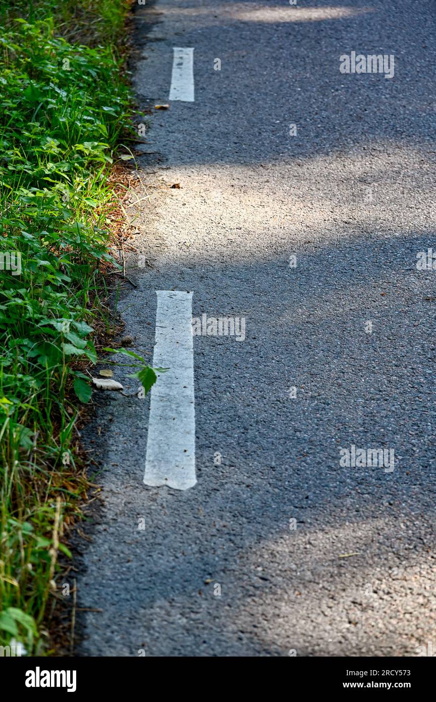 White lines on tarmac to mark the roads side Stock Photo - Alamy