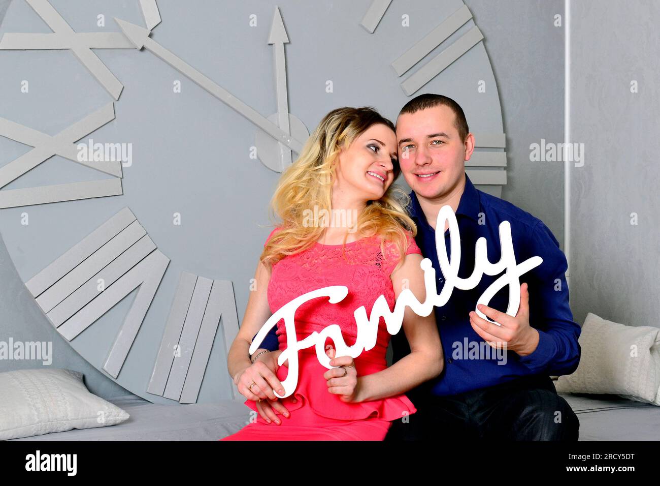 Attractive young couple is celebrating holiday at home. Standing on the ...