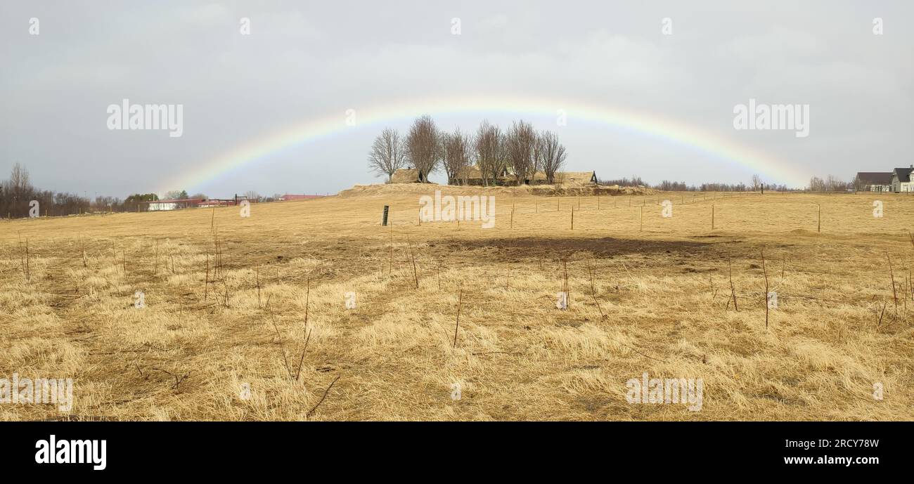 A rainbow shines above a group of trees near Reykjavik, Iceland. The ...